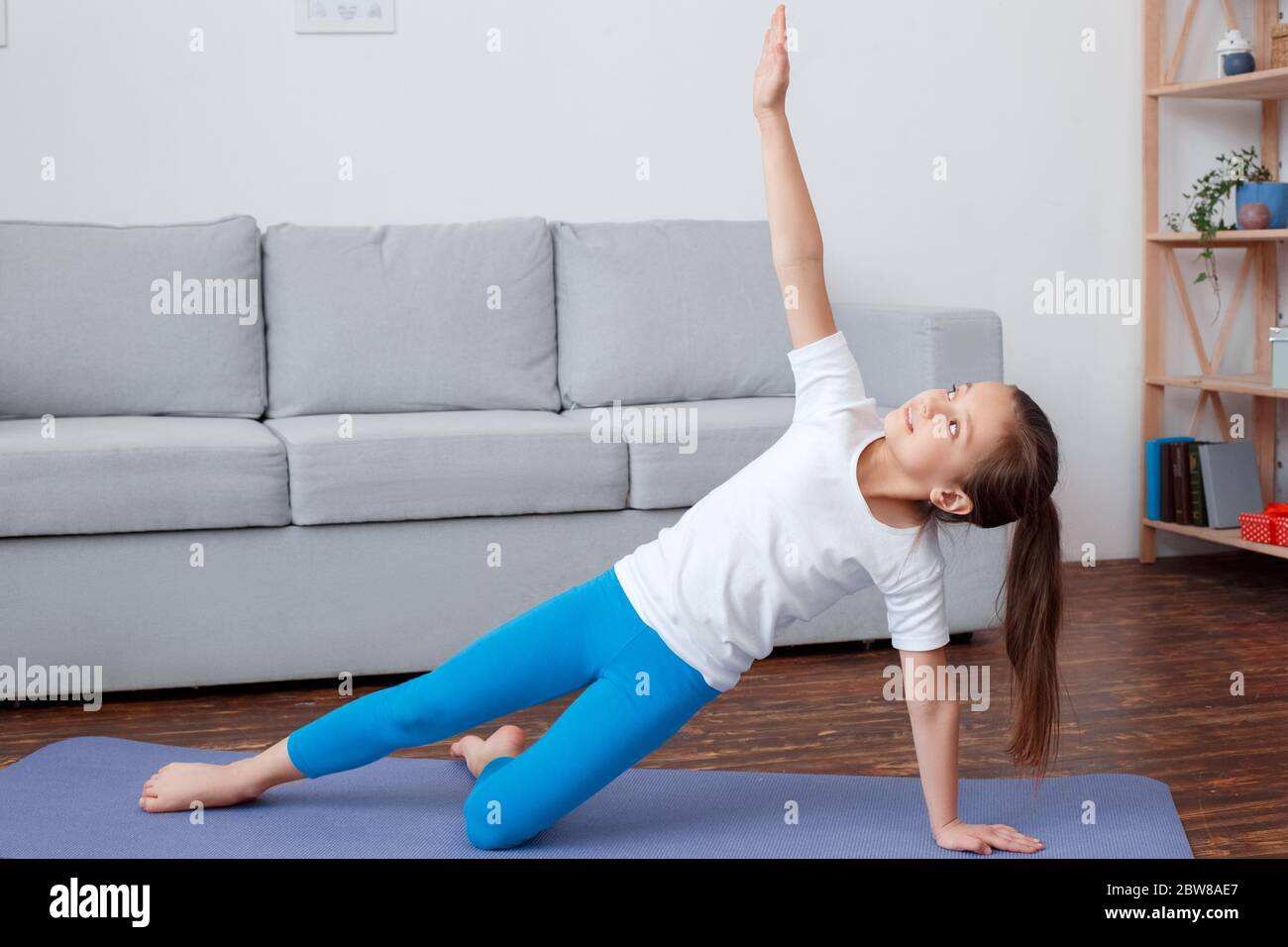 Charming and junior girl training at home Stock Photo - Alamy