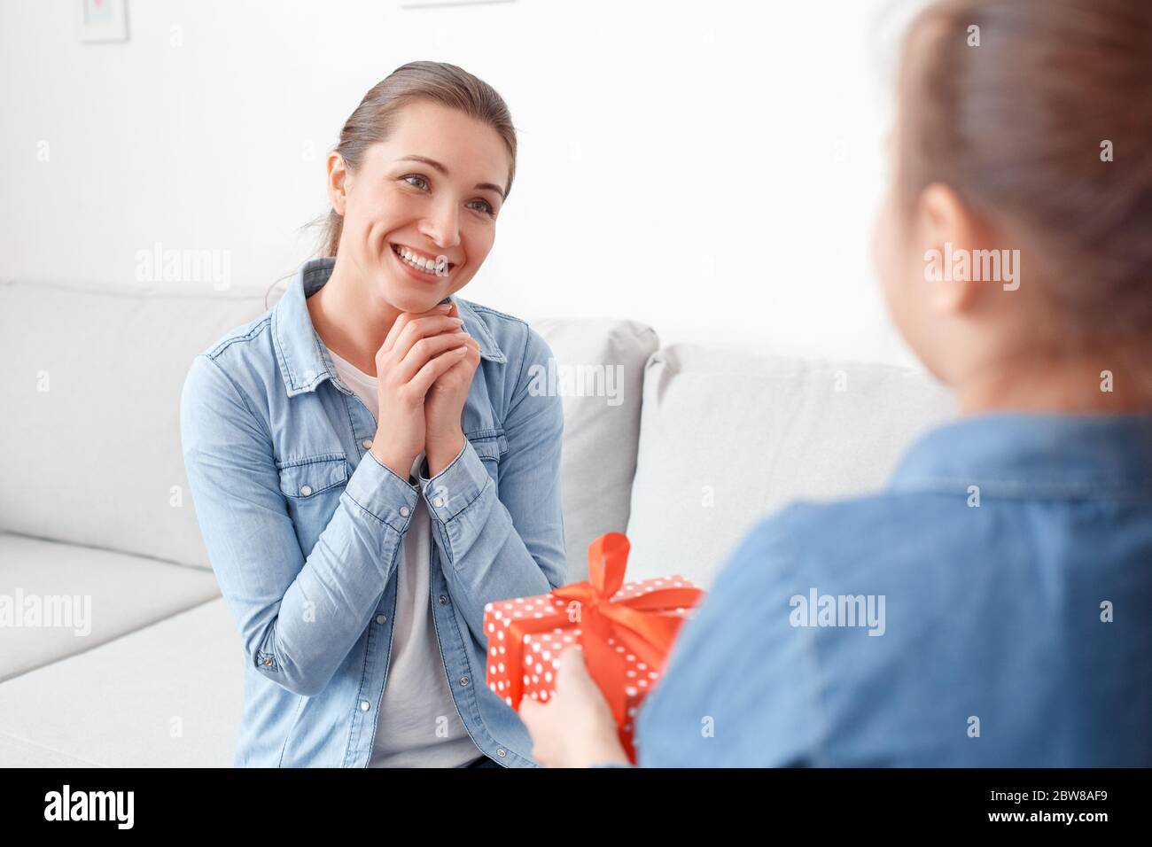 Little daughter giving present box to her smiling mother Stock Photo ...