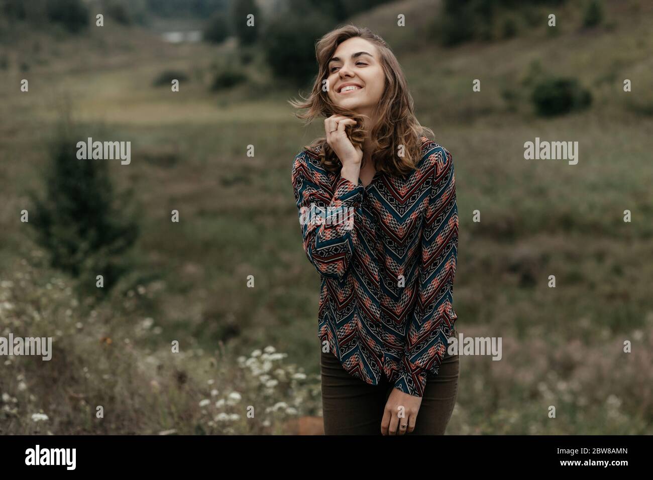 Happy woman standing in nature and smiling Stock Photo - Alamy