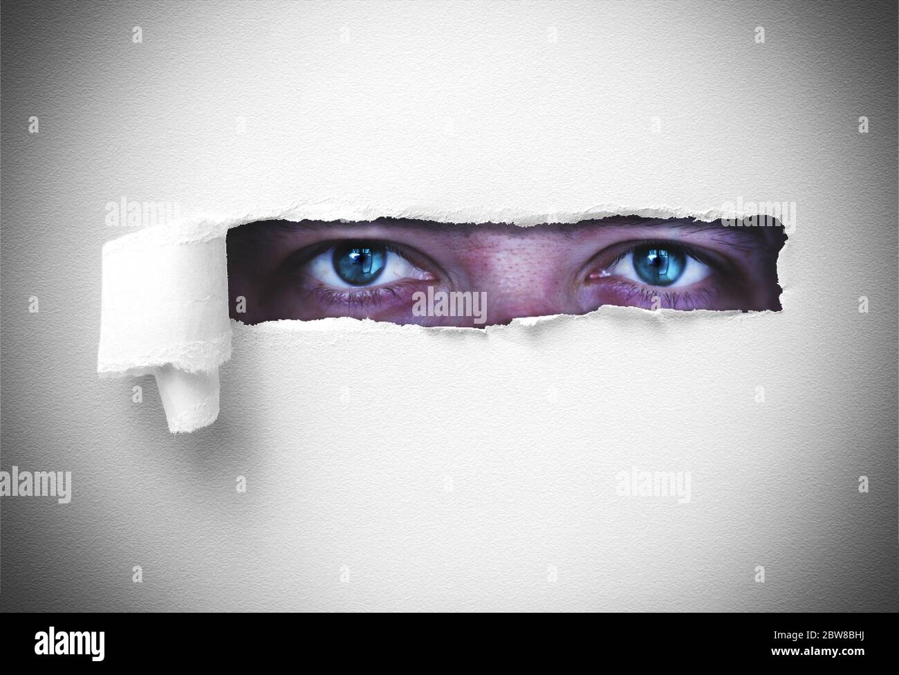 Blue eyes looking through torn white paper Stock Photo - Alamy