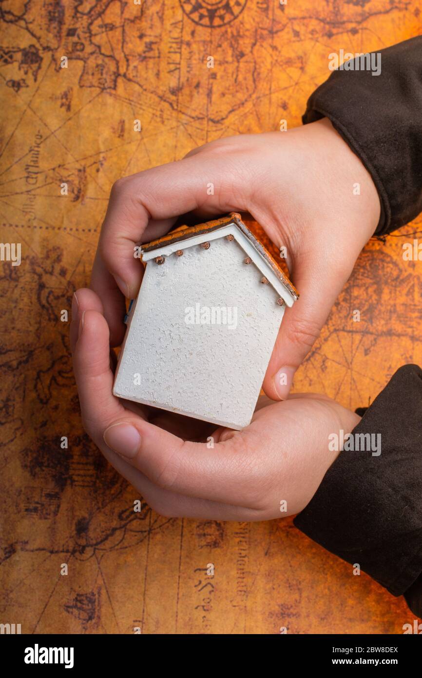 Model House on a vintage map background held by hands Stock Photo - Alamy