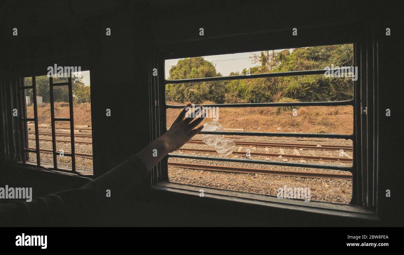 Indian people throw a plastic bottle and garbage from the train window ...