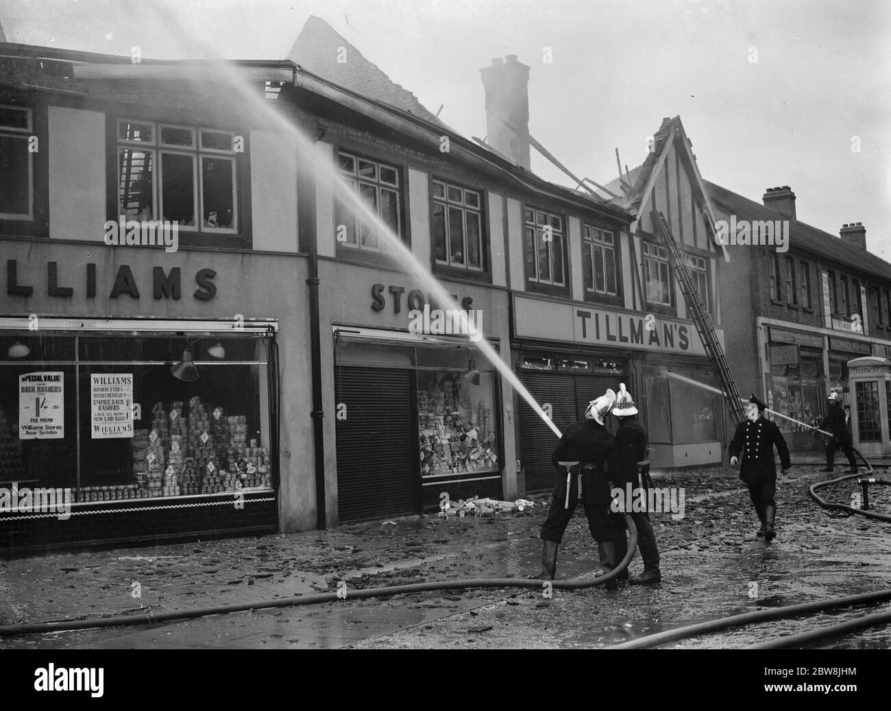 Firemen attempt to put out fires in a parade of shops in Welling , Kent ...