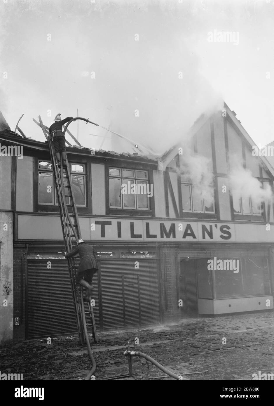 Firemen attempt to put out fires in a parade of shops in Welling , Kent ...