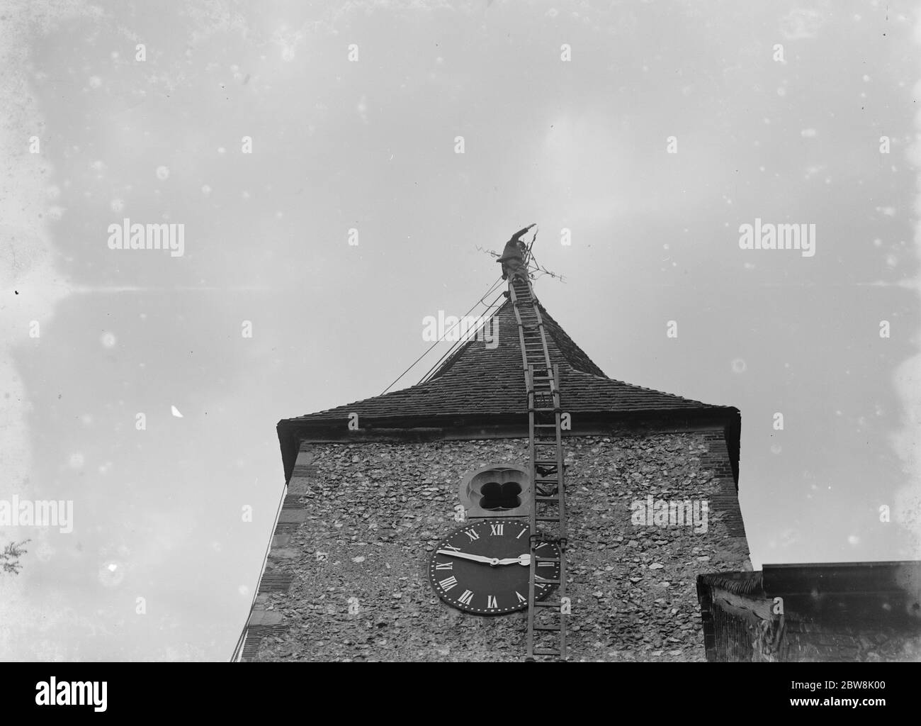 A steeplejack at work on top of St Mary Cray church tower . 1935 Stock ...