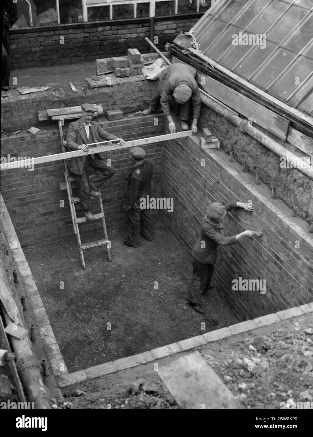Building the outer foundations for an air raid shelter in a garden in ...