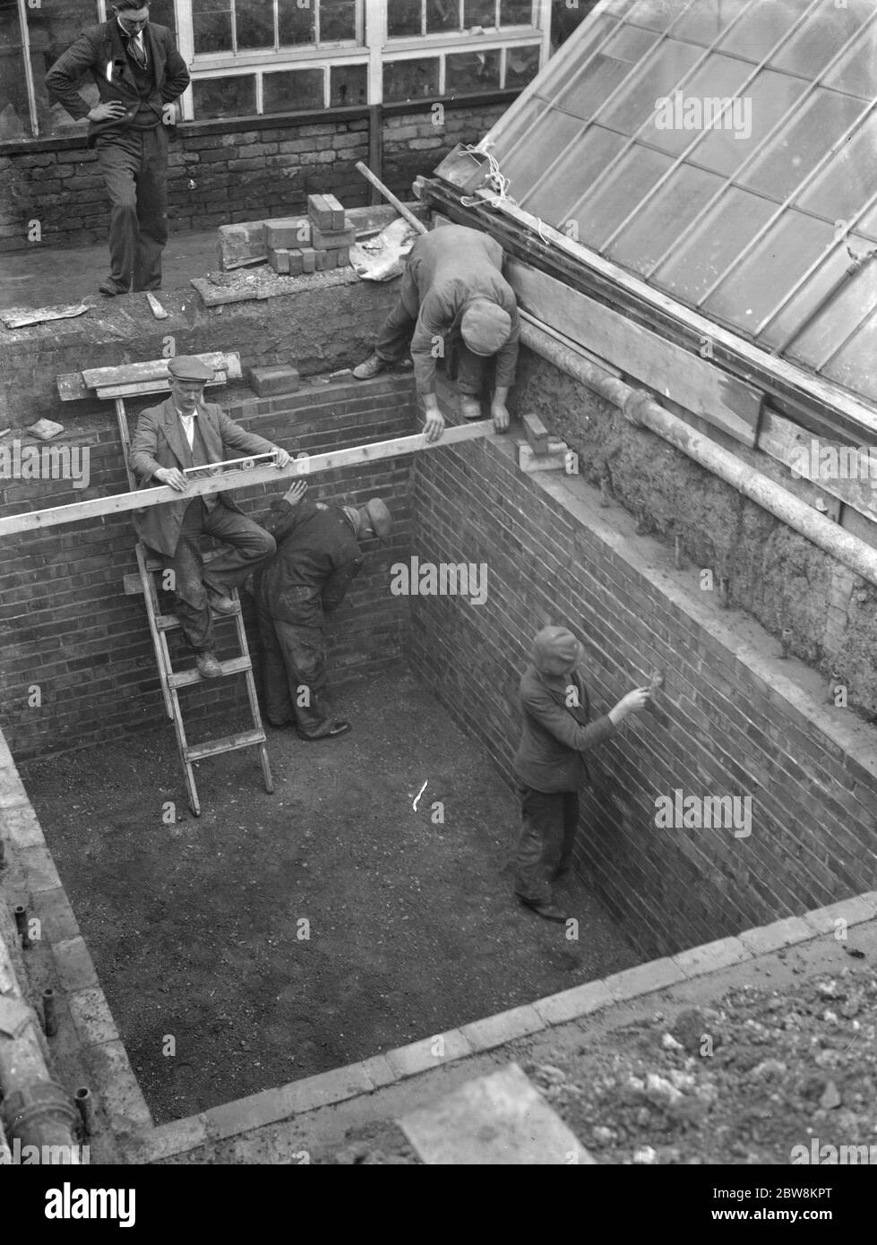 Building the outer foundations for an air raid shelter in a garden in ...