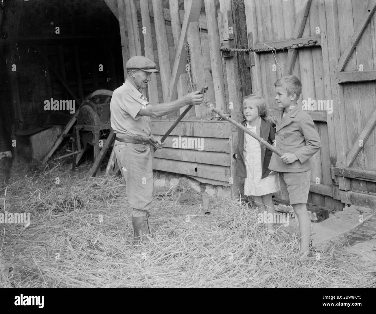 Jimmy Burrows showing flail to children . 1935 Stock Photo - Alamy
