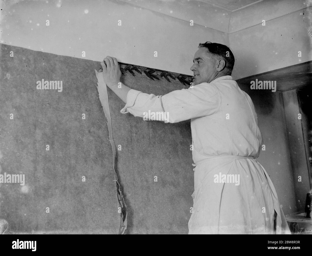 Mr Tidy the plumber doing a spot of wallpapering . 1936 Stock Photo - Alamy