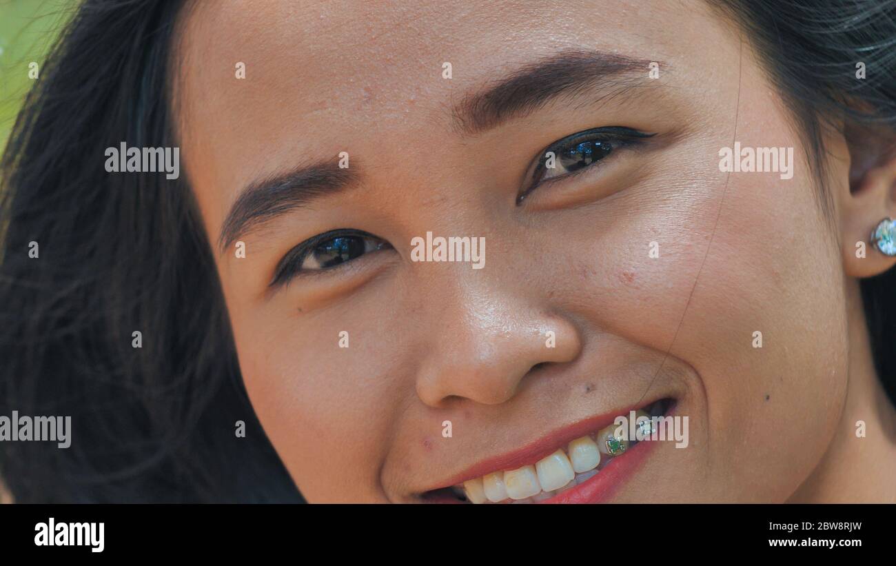 Portrait of a smiling Indonesian girl in a park. Face close-up Stock ...