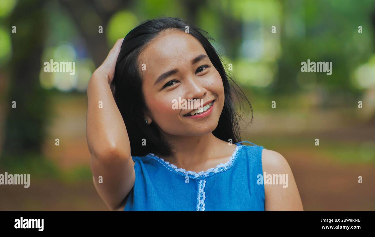Portrait of a smiling Indonesian girl in a park Stock Photo - Alamy