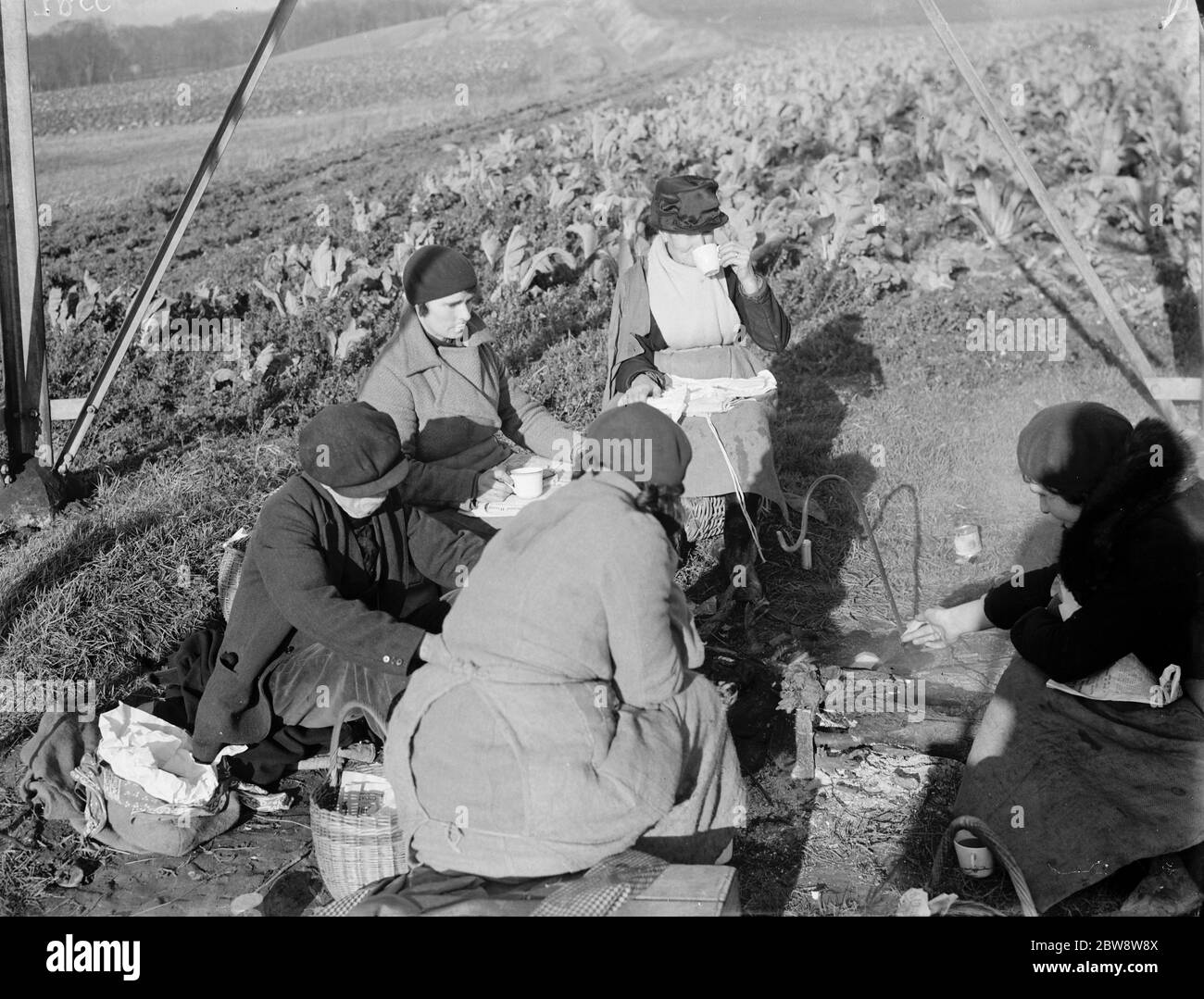 Farm workers sitting under a pylon , eating their lunch . 1936 Stock ...