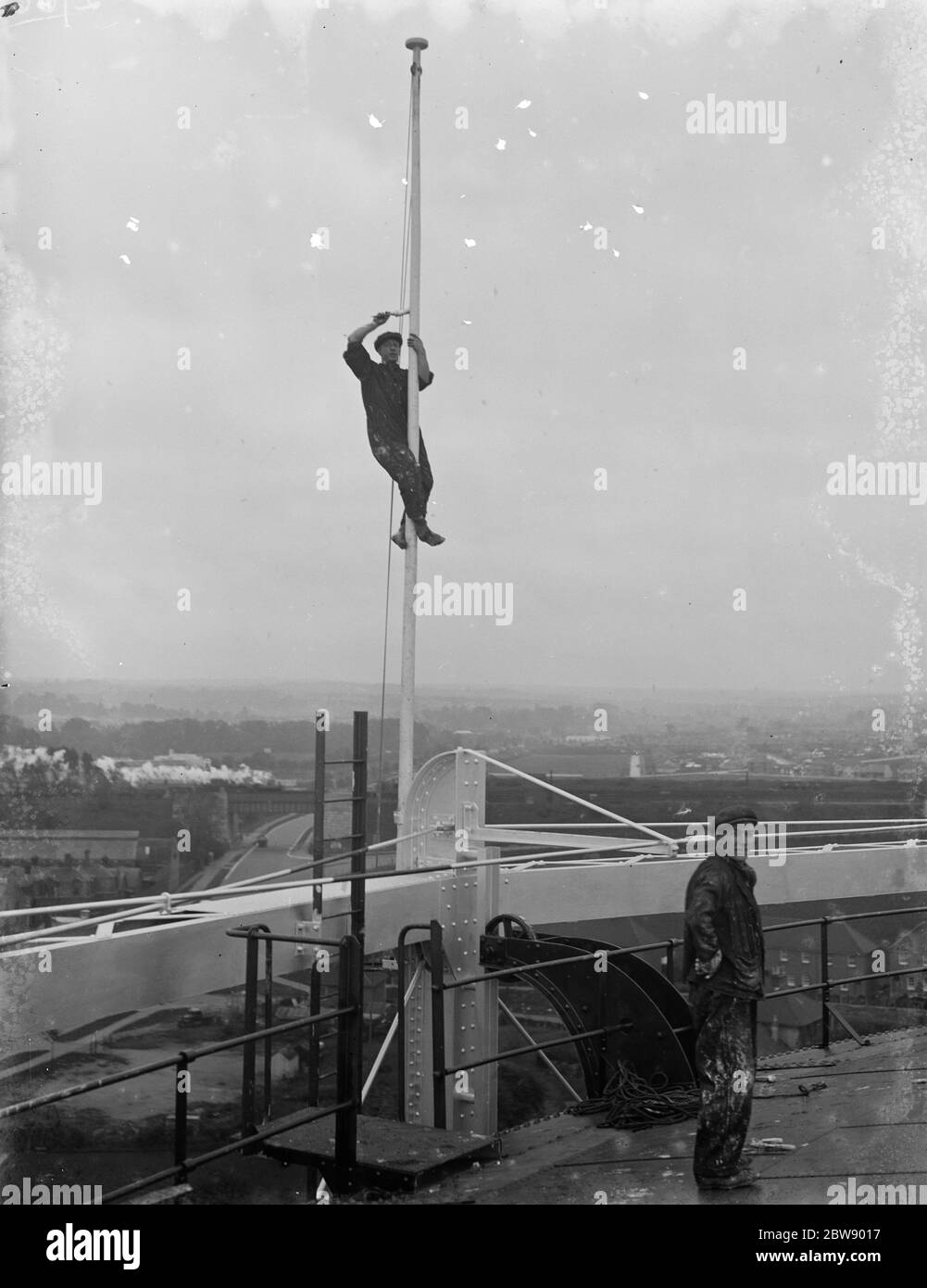 A man on the top of a gasometer painting the flag staff . 1936 Stock ...