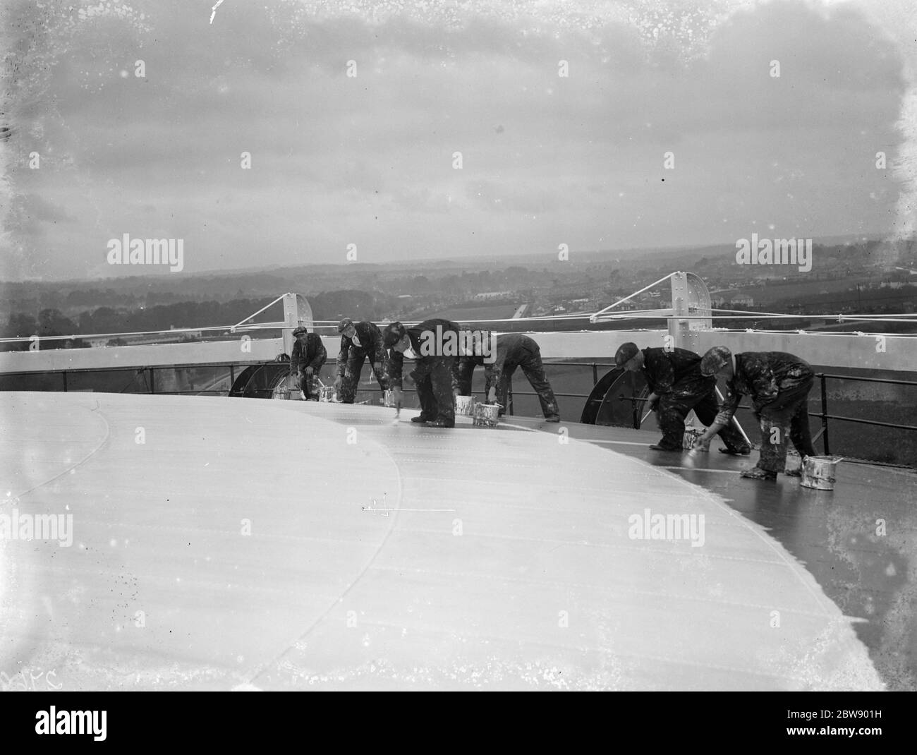Workmen painting the top of a gasometer . 1936 Stock Photo - Alamy