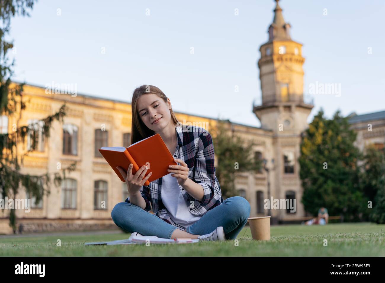 Successful university student studying, reading a book, learning ...