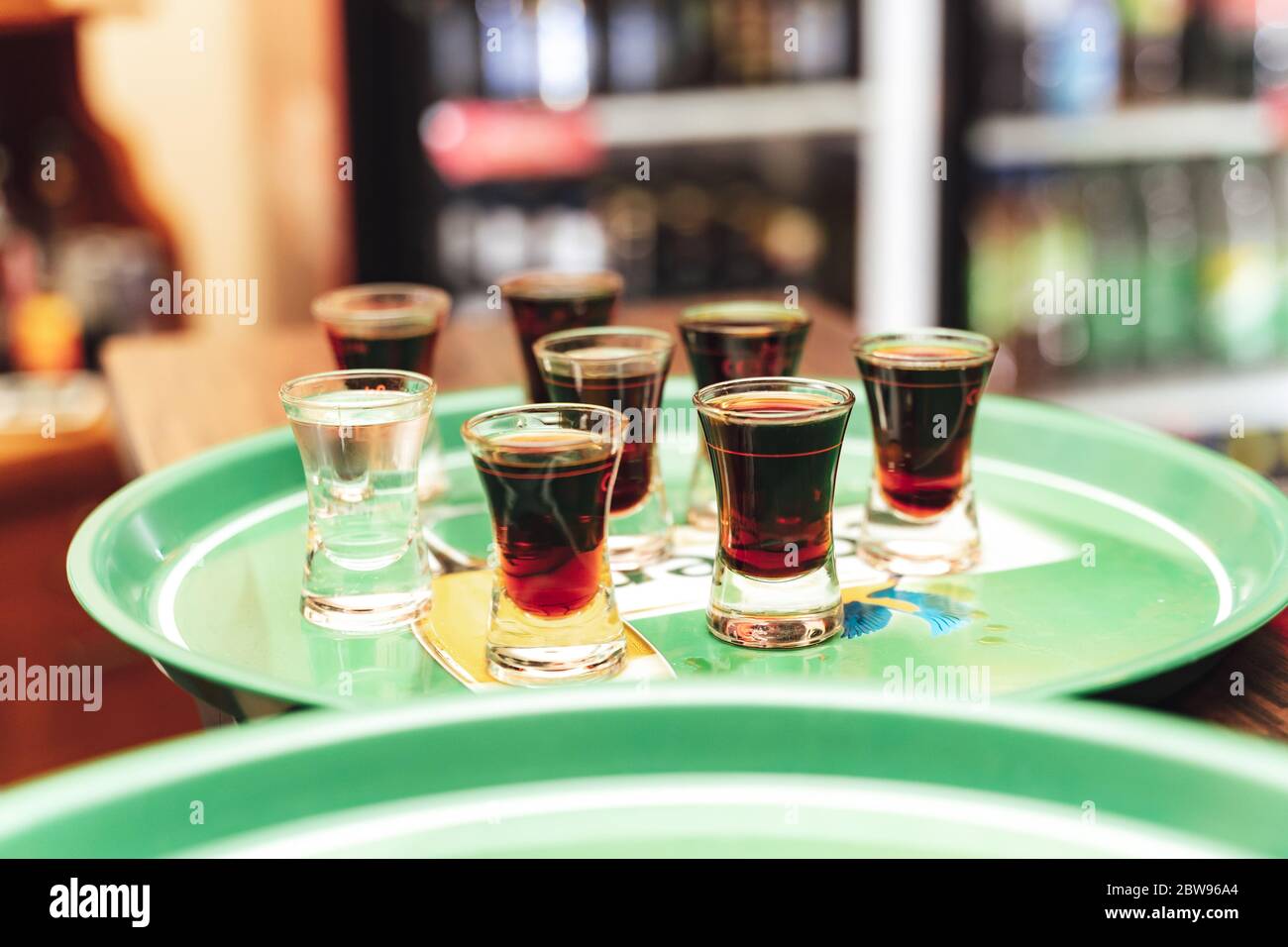 Several glasses of various colorful shots of alcohol laying on green ...