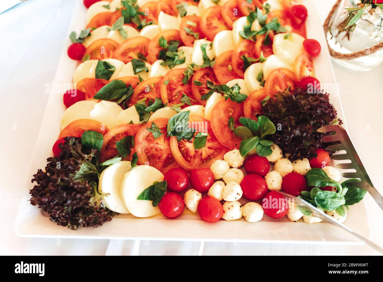 Fresh vegetarian salad with tomato, mozzarella and lettuce on white ...