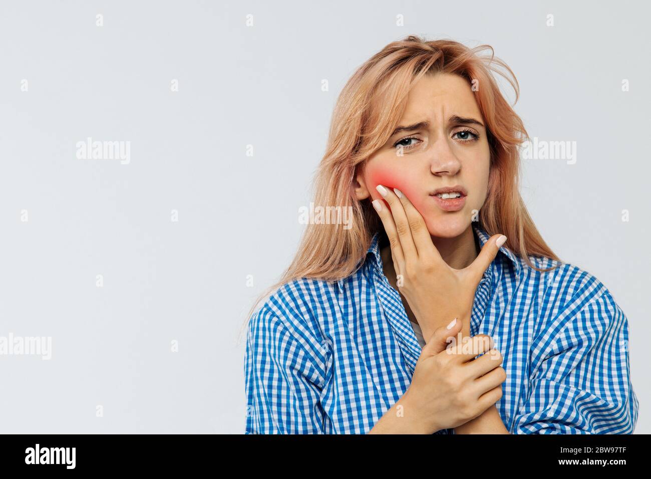 Studio portrait of young woman feeling painful suffering from toothache ...