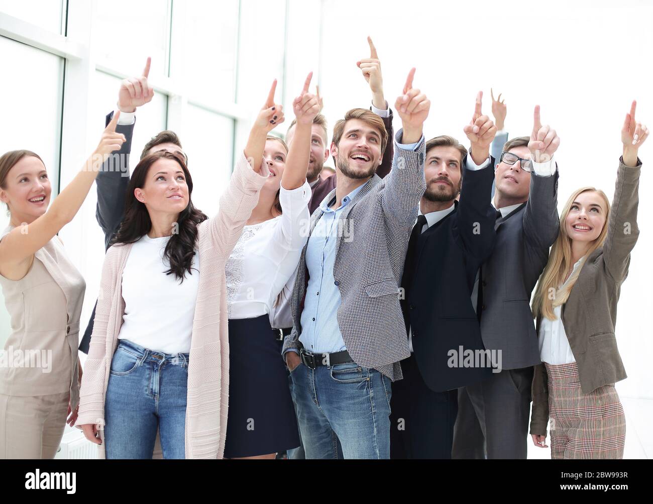 group of happy young business people pointing upwards Stock Photo - Alamy