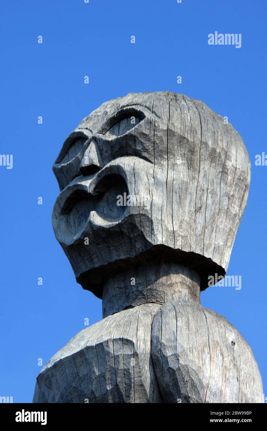 Hawaiian statue is framed by blue sky. Statue stands guard over ...