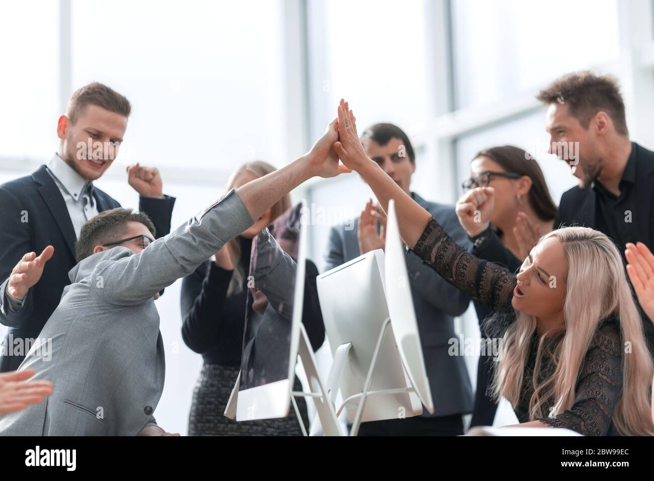 happy employees giving each other a high five Stock Photo - Alamy