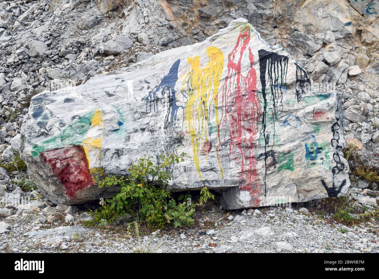 Painted rock in the middle of mountains Stock Photo - Alamy