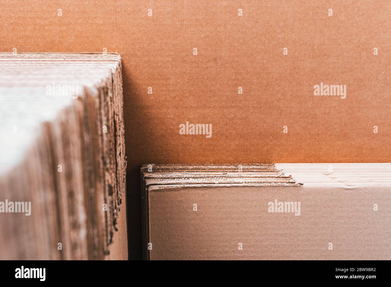 Cardboards stacked on a white wall ready to form boxes to transport ...