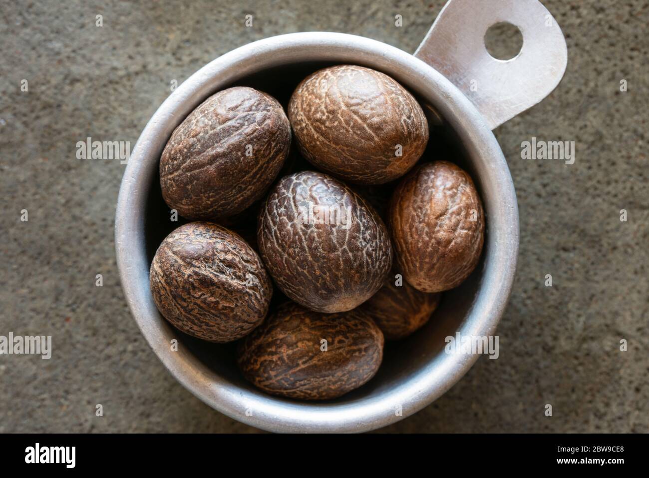 Whole Nutmeg in a Measuring Cup Stock Photo - Alamy