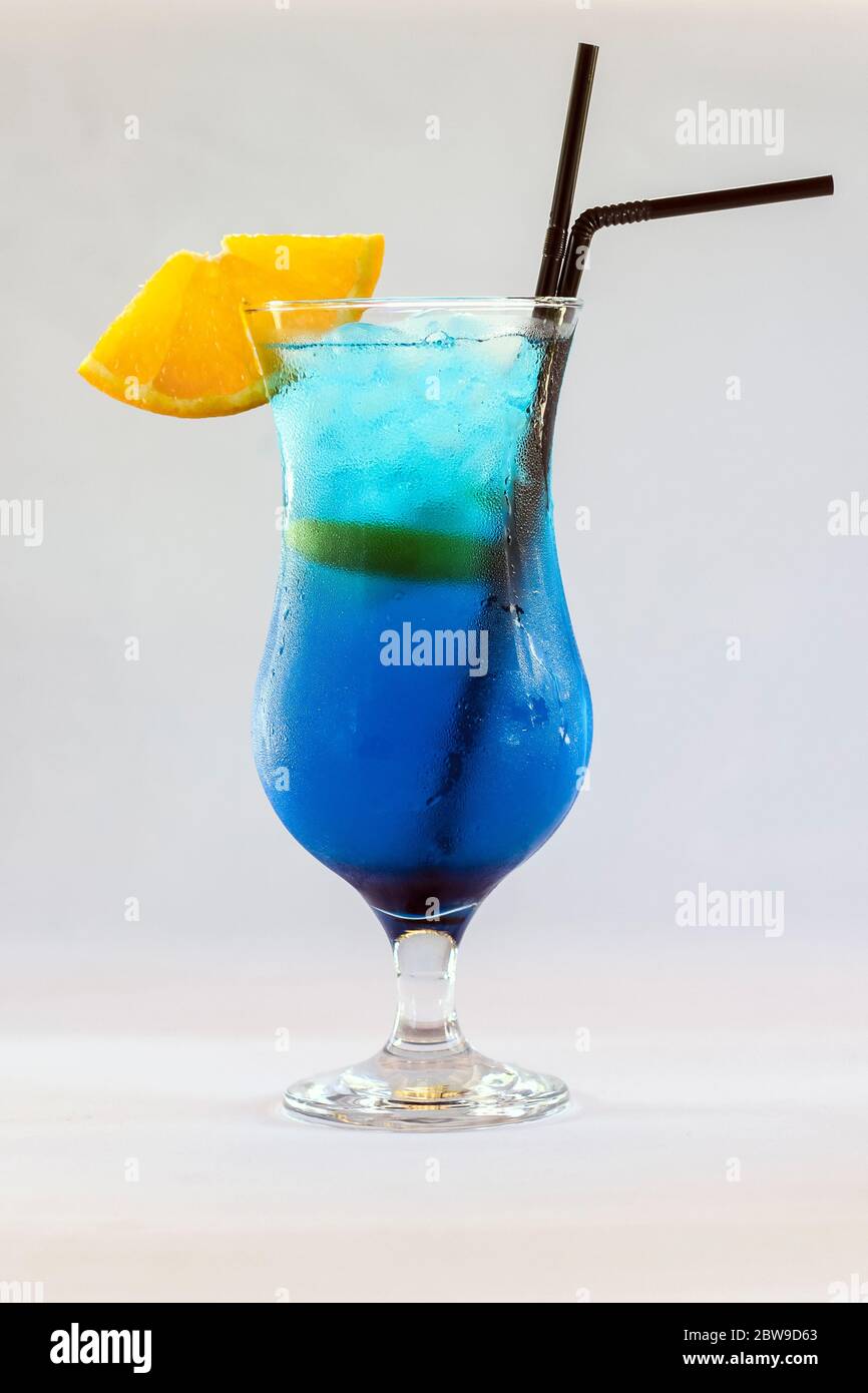 A fresh summer fruit and citrus blue coloured cocktail with a piece of ...