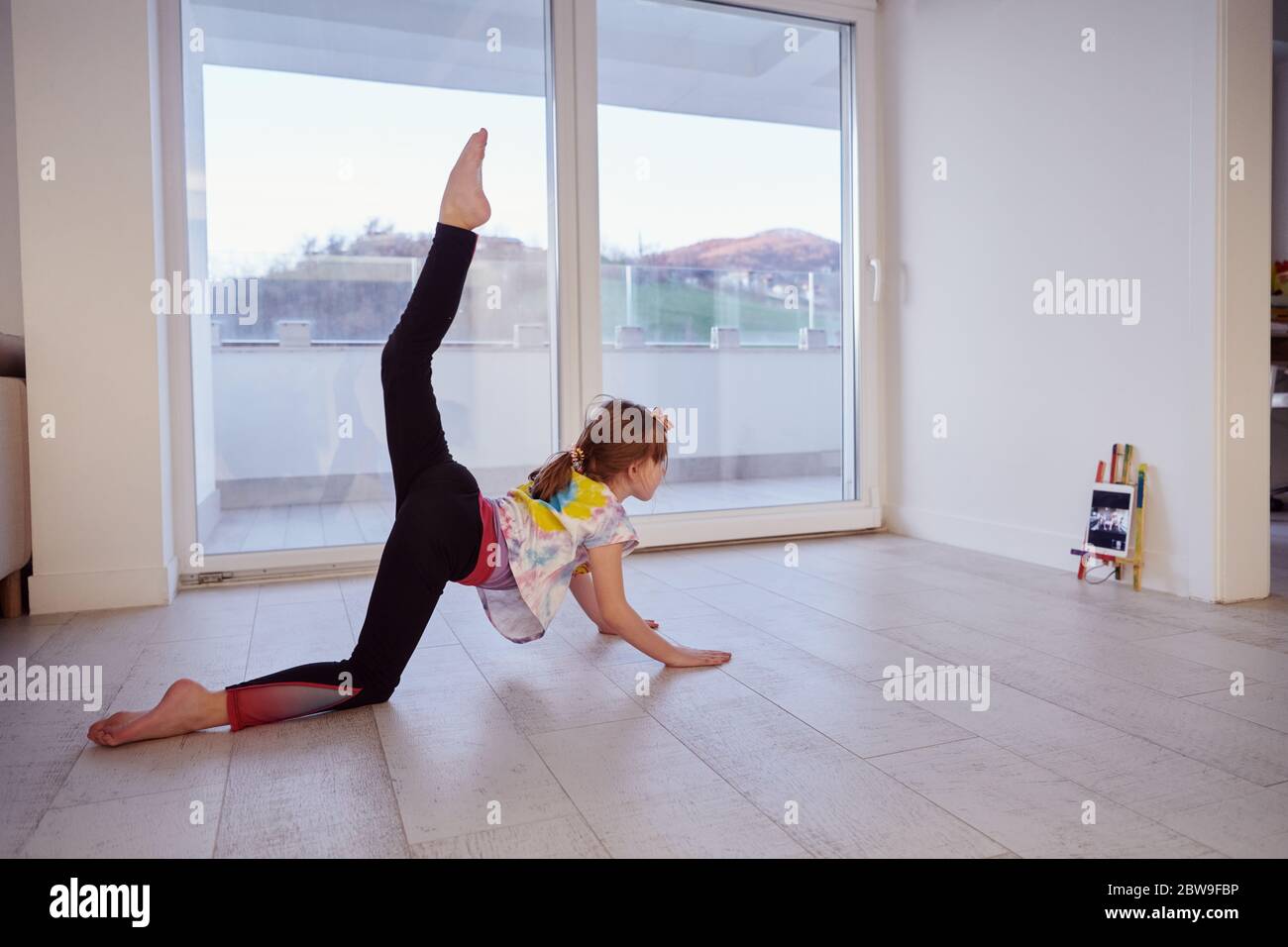 Little girl have online training over tablet and doing modern ballet ...