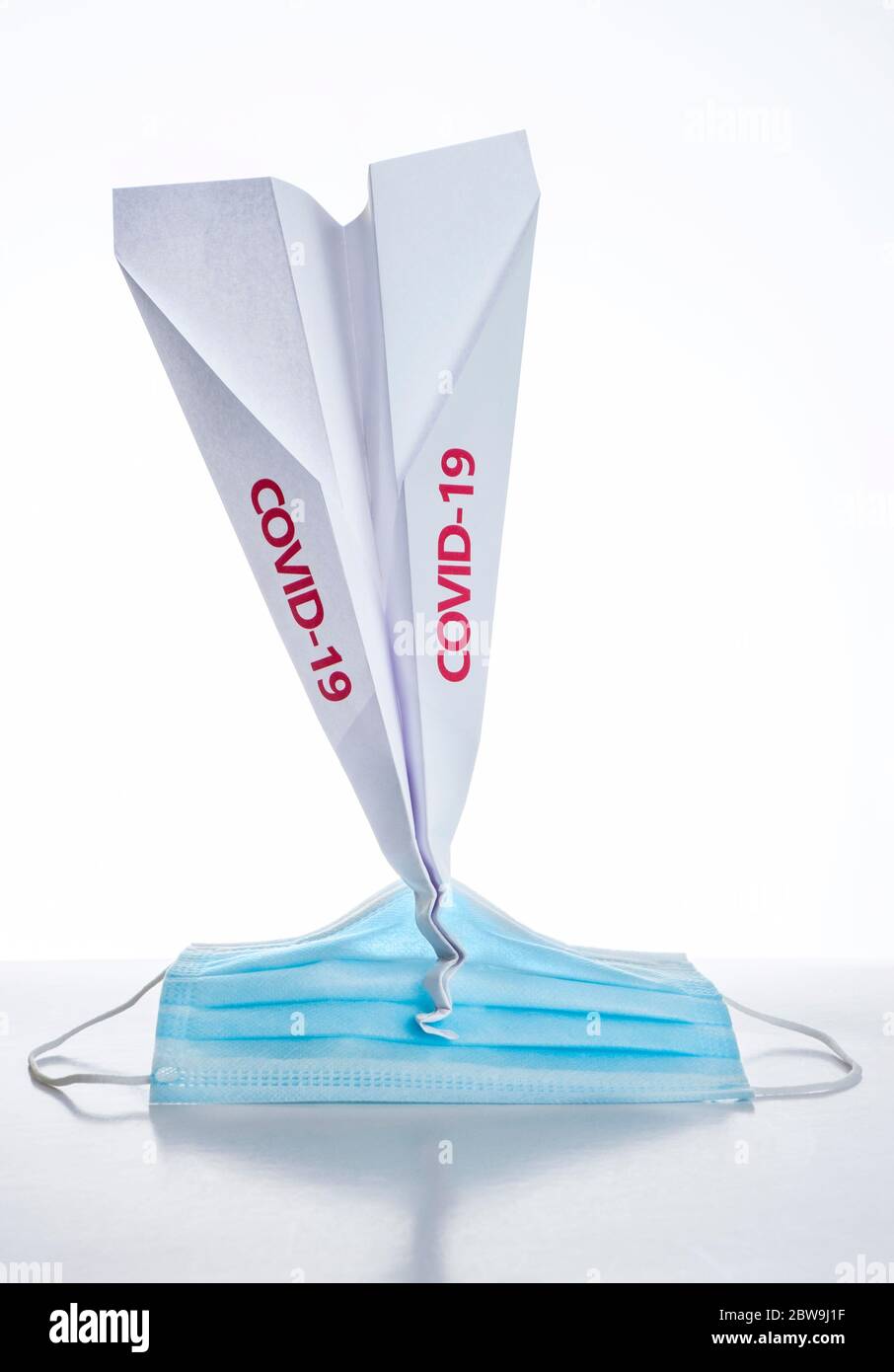 Studio shot of paper plane with Covid-19 sign and surgical mask Stock ...