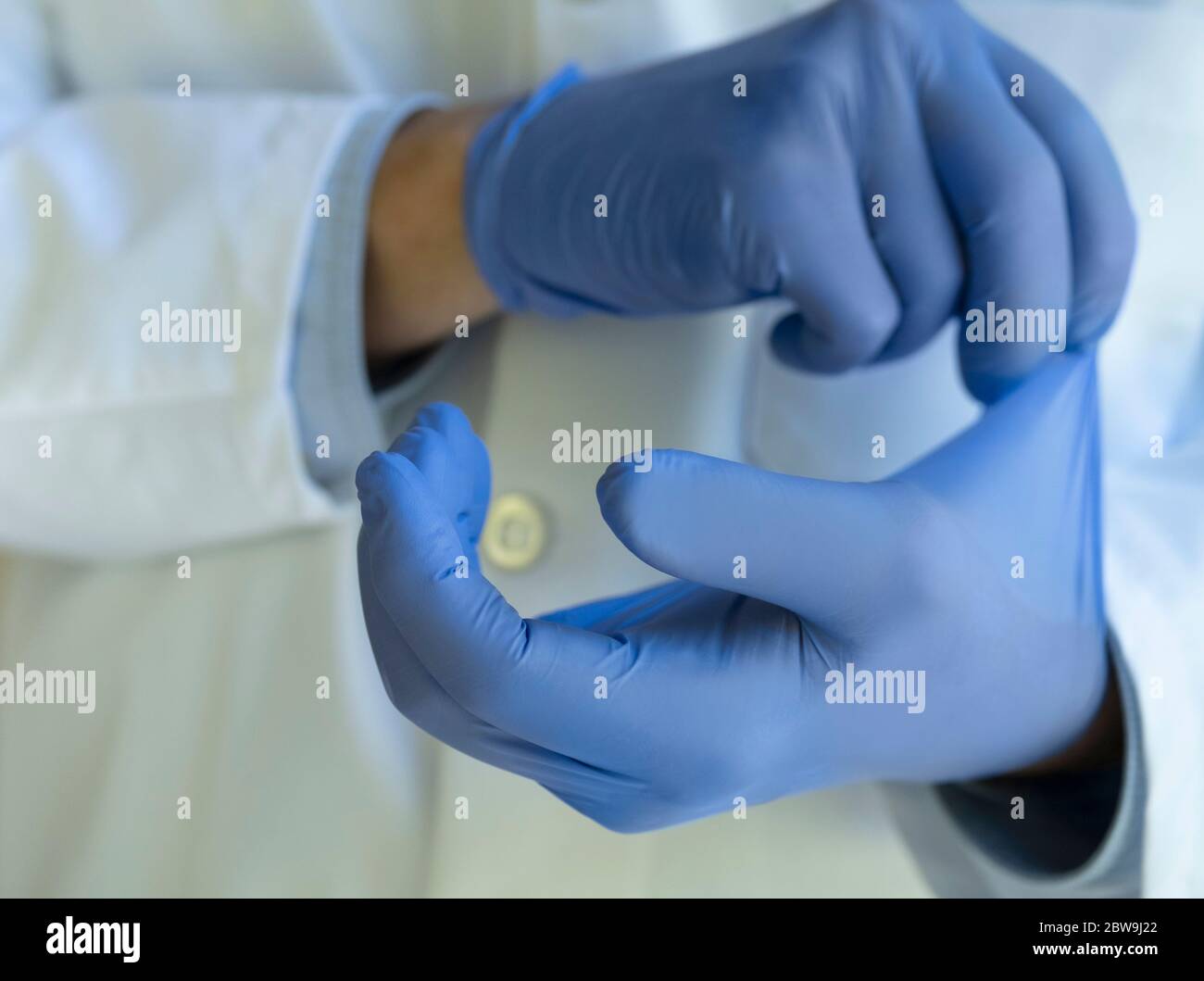 Doctor putting on latex gloves hi-res stock photography and images - Alamy