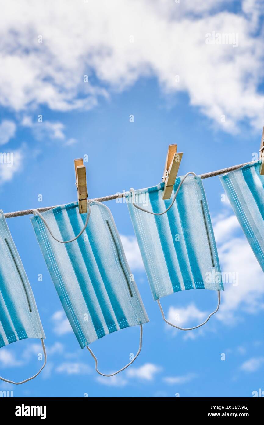 Row of surgical masks hanging on clothesline with sky in background ... Row of surgical masks hanging on clothesline with sky in background ...