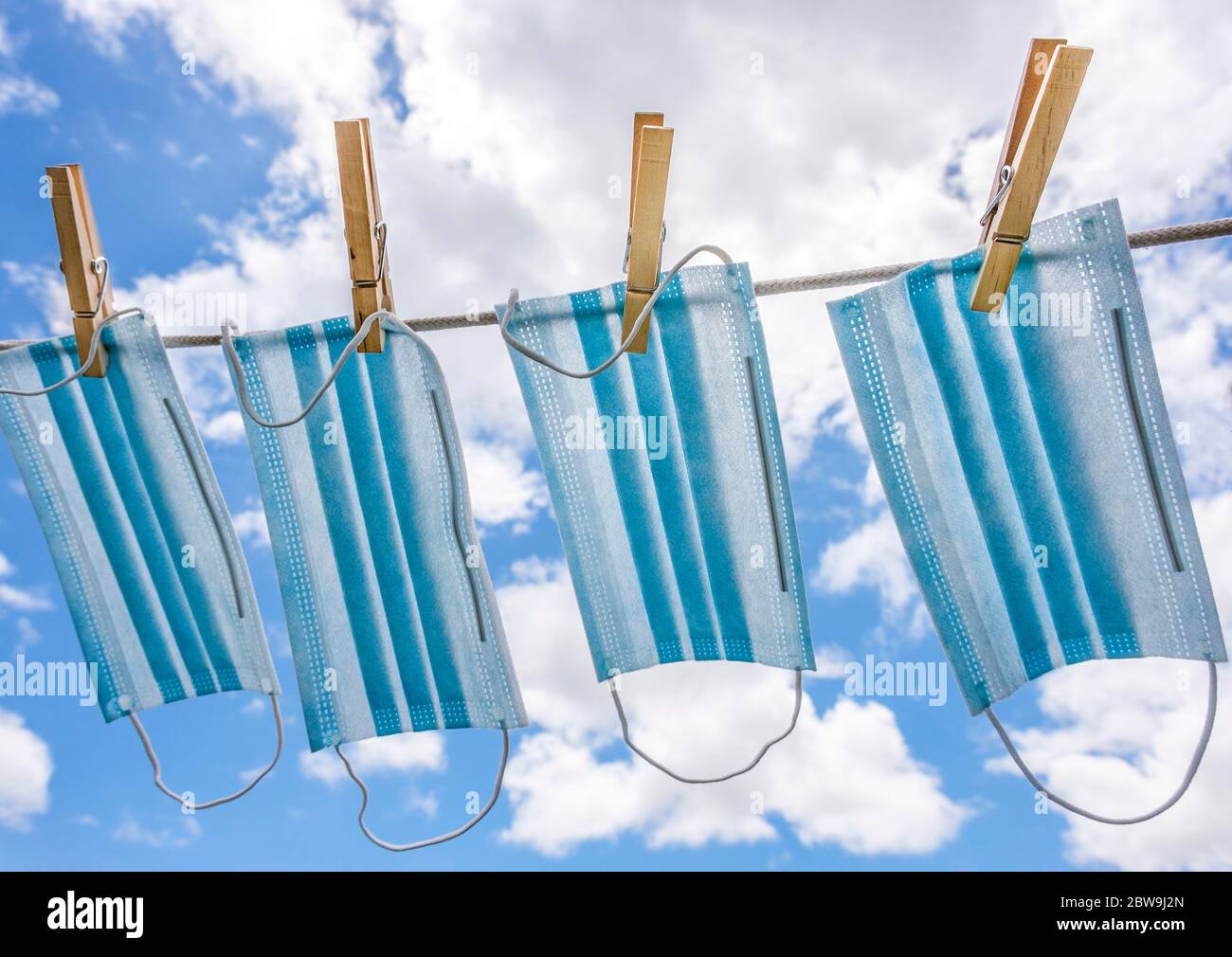 Row of surgical masks hanging on clothesline with sky in background ... Row of surgical masks hanging on clothesline with sky in background ...