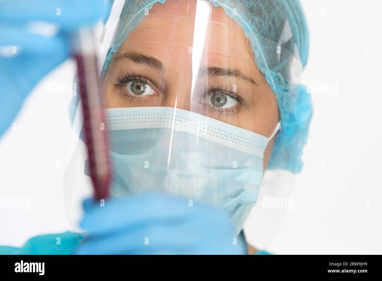 Nurse in mask and face shield holding blood sample Stock Photo - Alamy