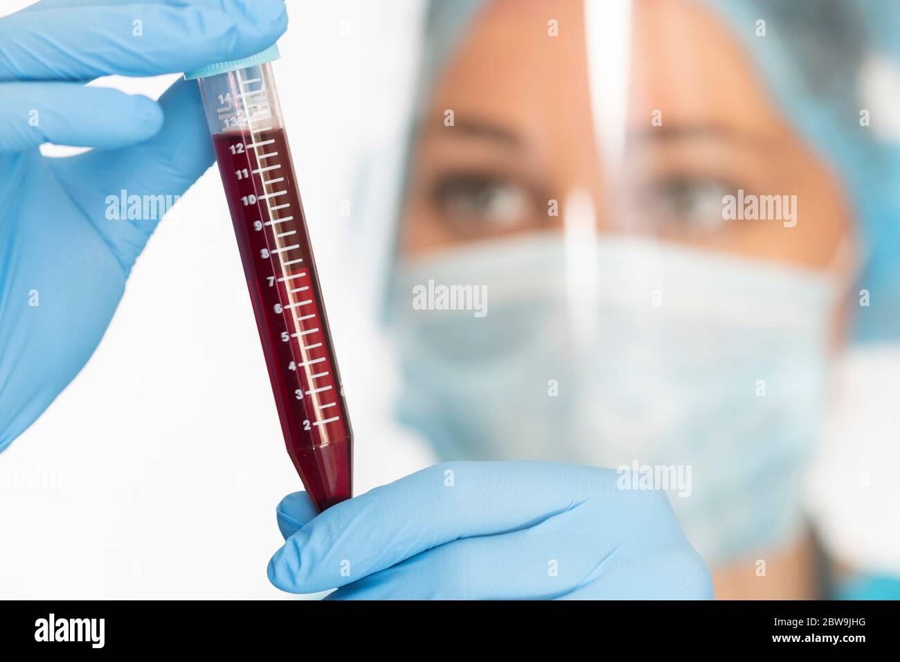 Nurse in mask and face shield holding blood sample Stock Photo - Alamy