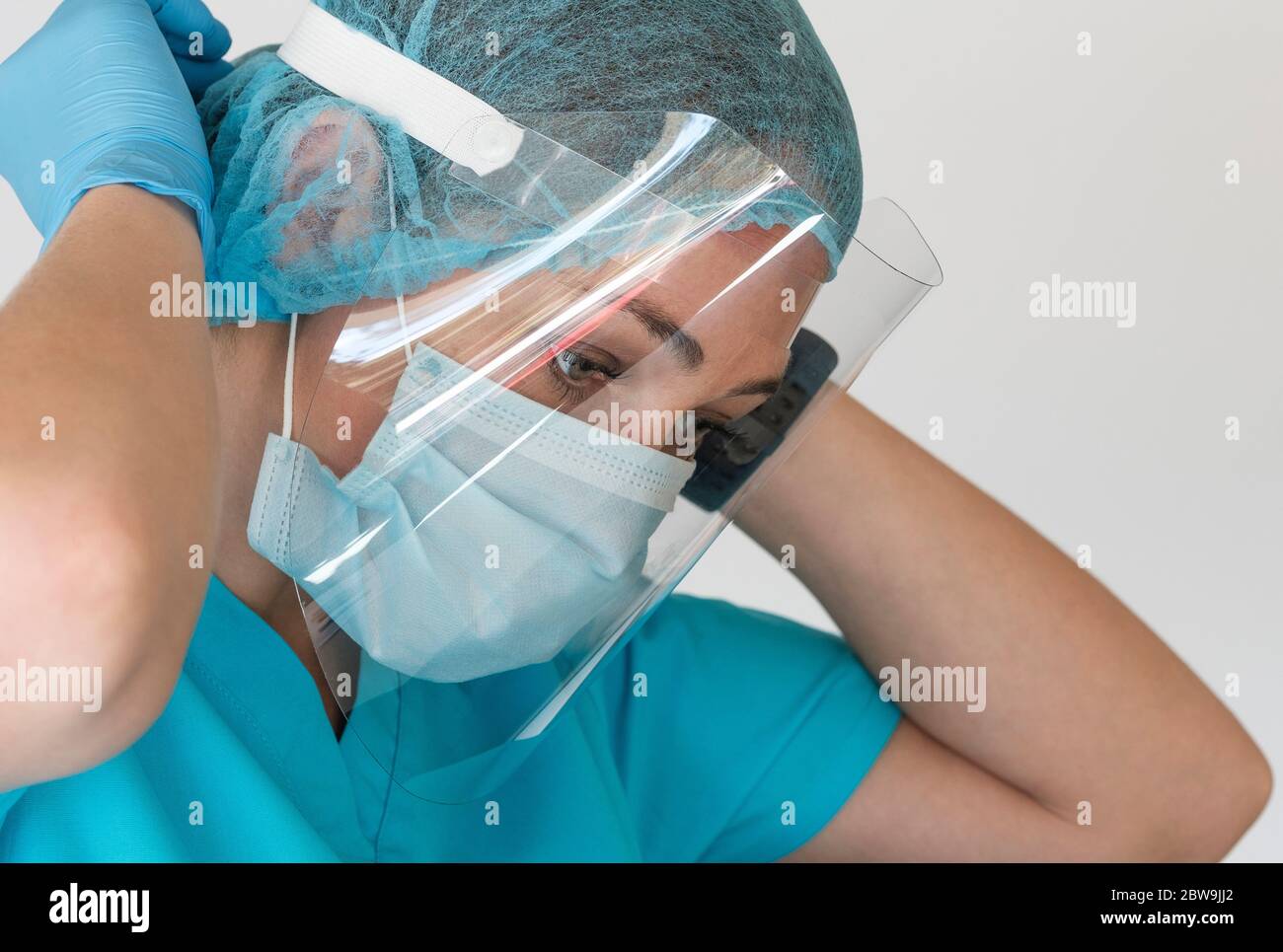 Nurse putting on face shield Stock Photo - Alamy