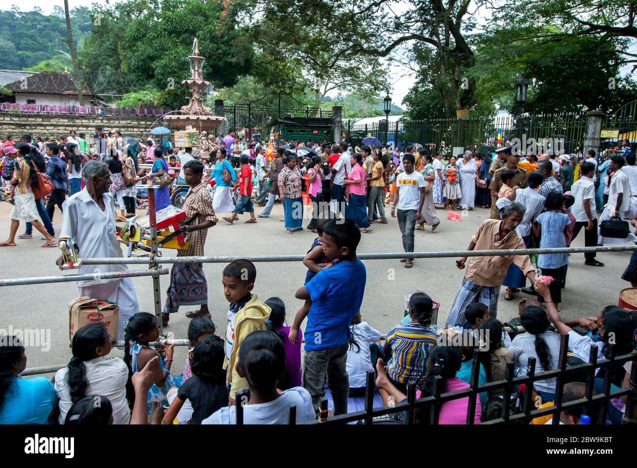 A huge crowd of people congregate on a street at Kandy in Sri Lanka ...