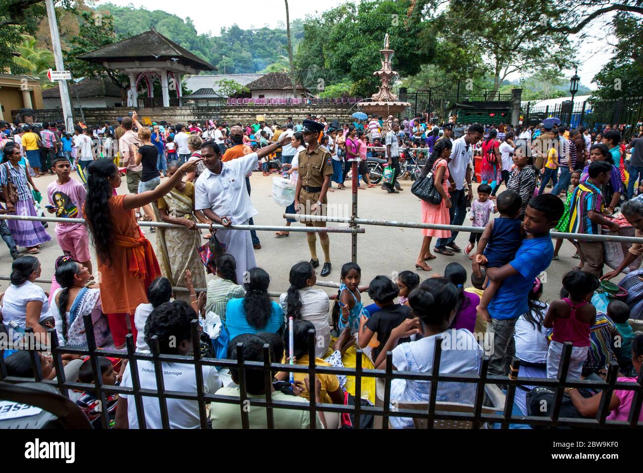 A huge crowd of people congregate on a street at Kandy in Sri Lanka ...