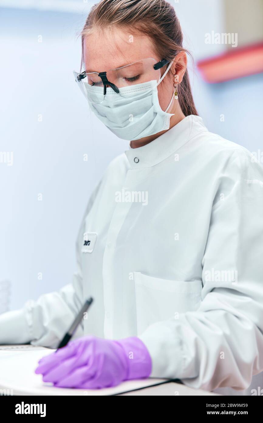 Female technician writing in notebook Stock Photo - Alamy