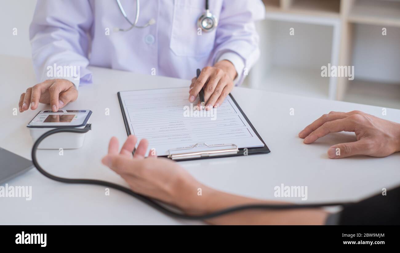 Doctor using sphygmomanometer or tonometer measuring blood pressure to ...