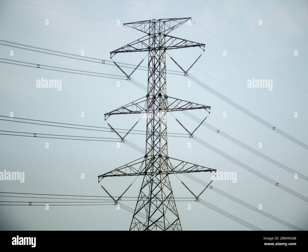High-voltage pylons on a blue sky background Stock Photo - Alamy