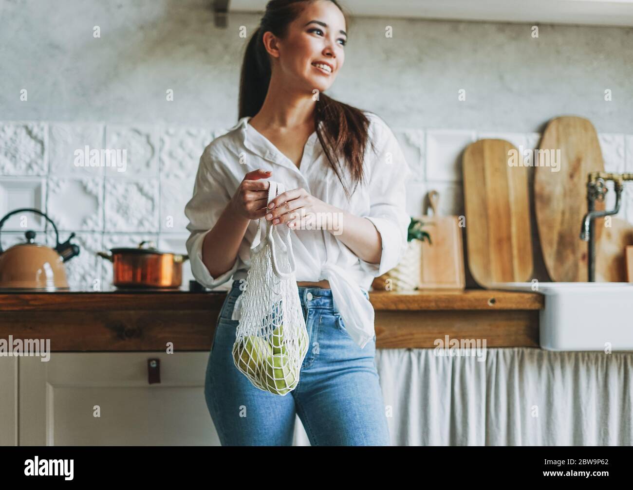 Young asian woman in white shirt hold knitted rag bag shop with green ...