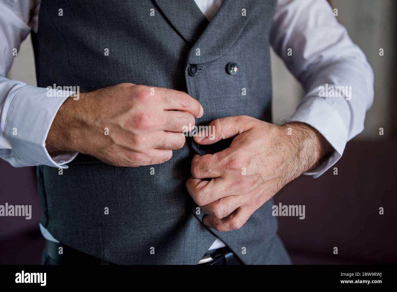man fastens a button on jacket Stock Photo - Alamy