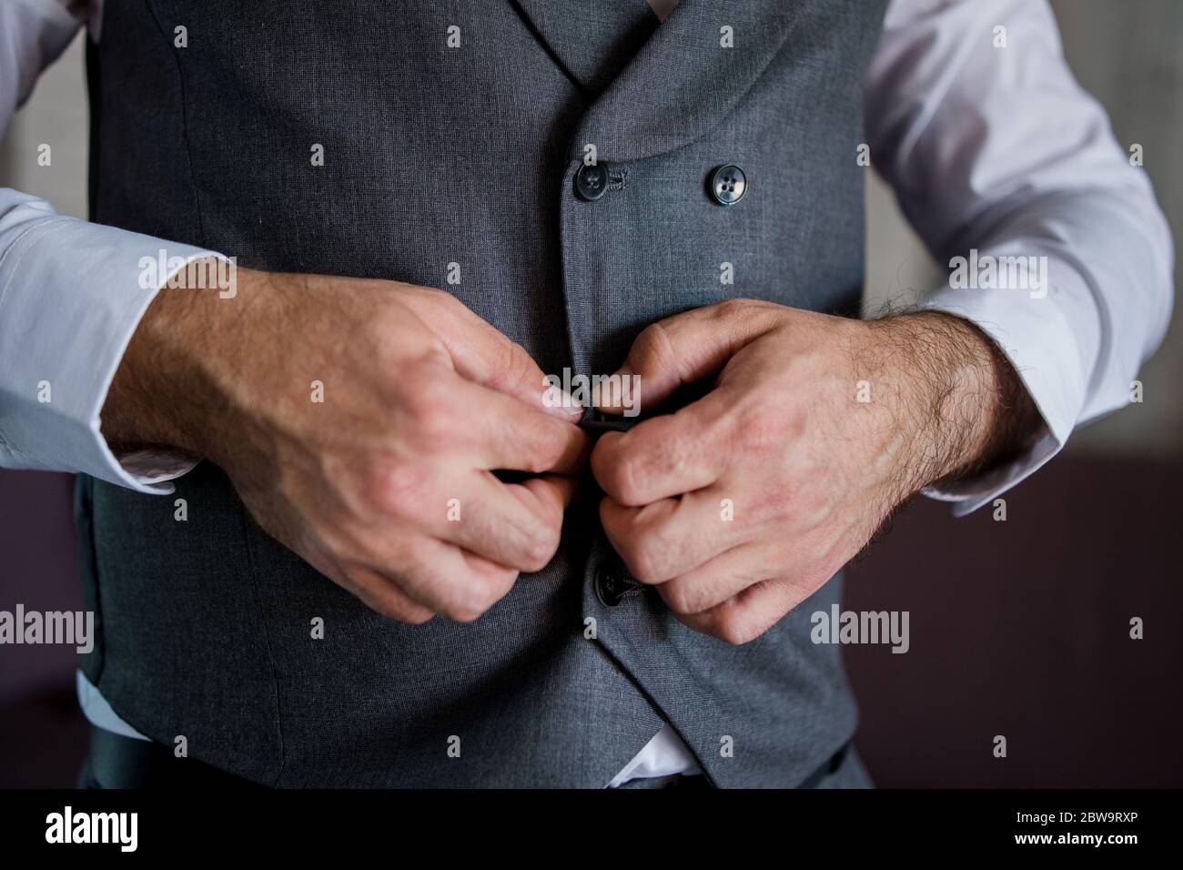 man fastens a button on jacket Stock Photo - Alamy