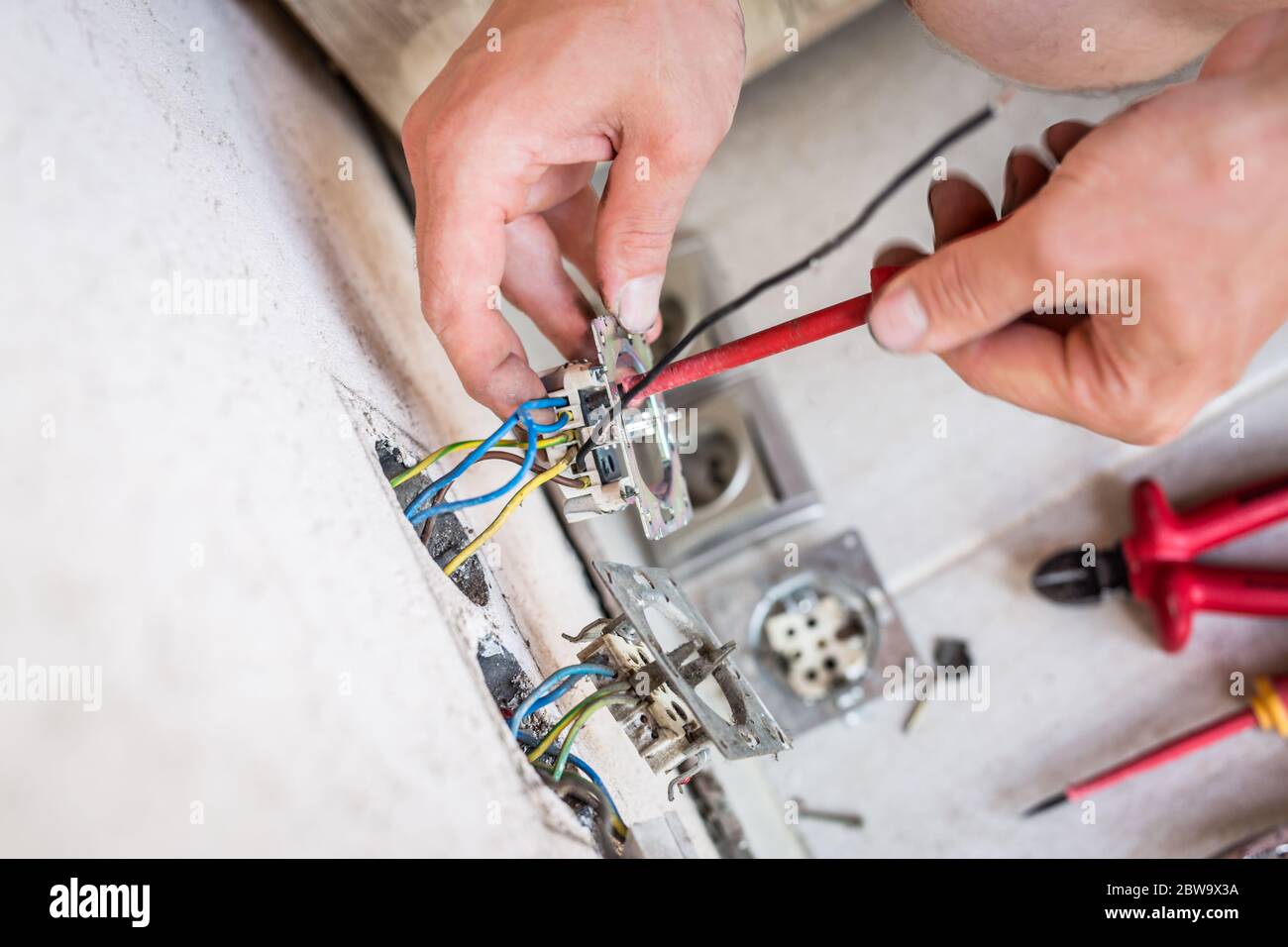 Closeup of electrician hands fixing a socket Stock Photo - Alamy