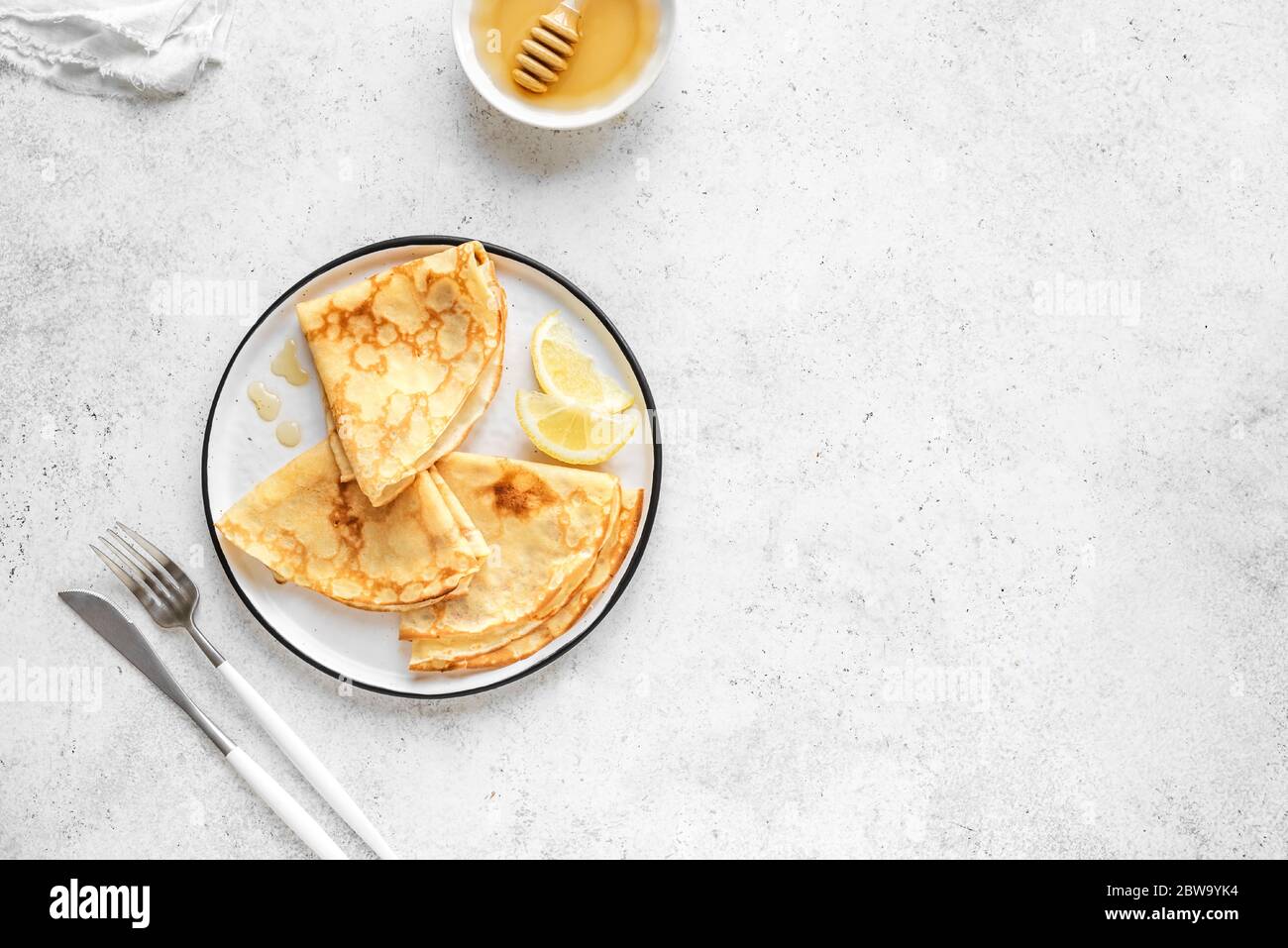 Crepes with lemon and honey on white background, top view, copy space ...