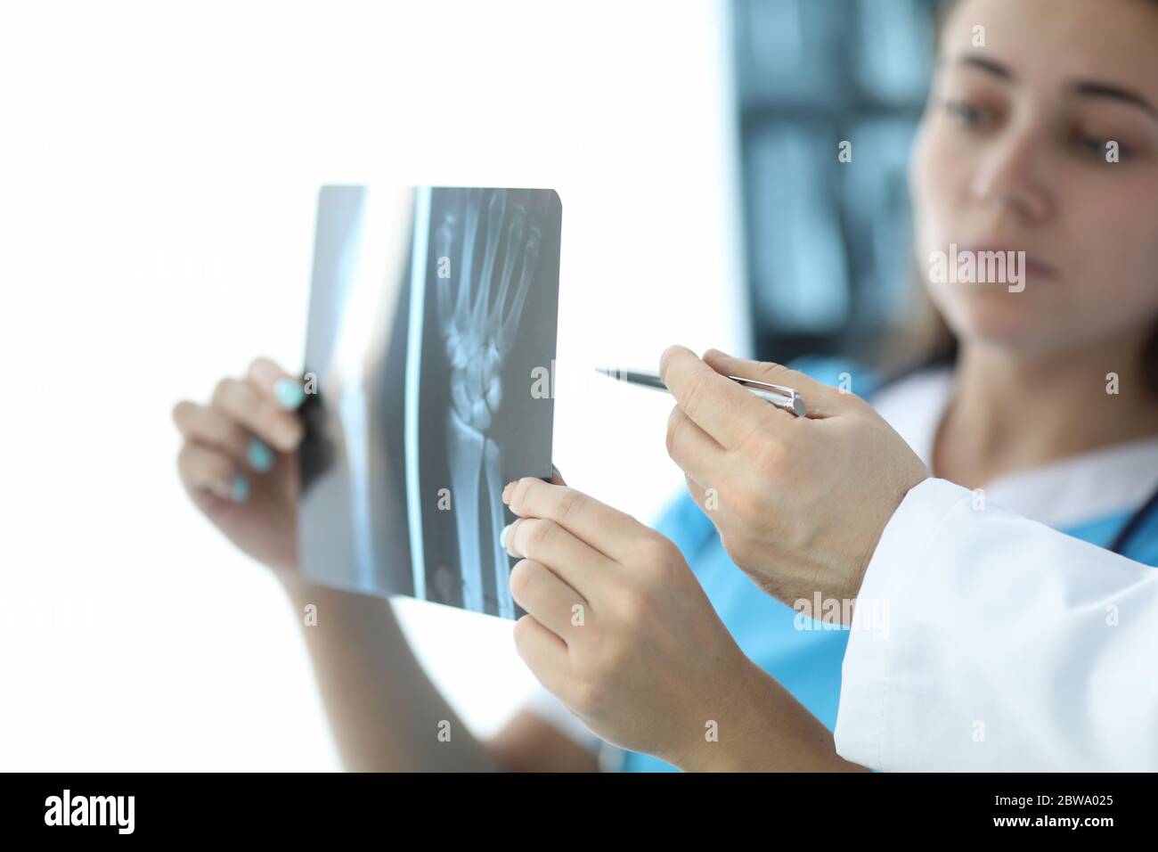 Woman looks at an x-ray hand, next to doctor Stock Photo - Alamy