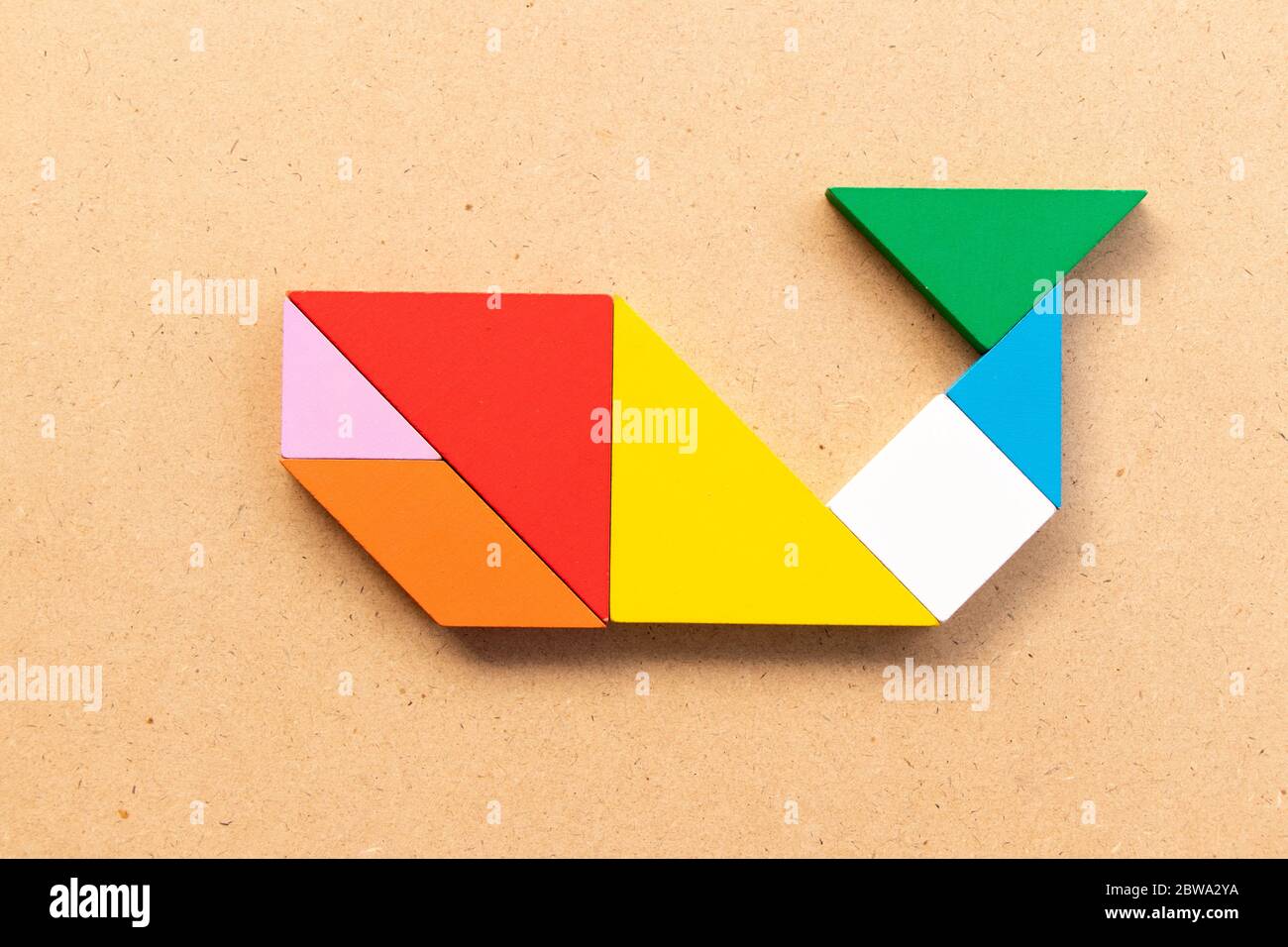 Color tangram puzzle in whale, fish or shark shape on wood bacground ...