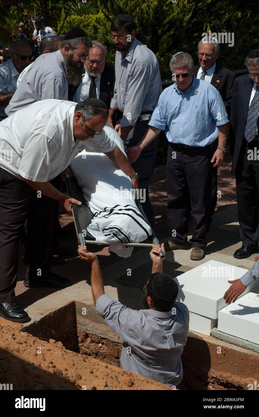 Orthodox Jewish pallbearers lower the shroud-covered body of renowned ...